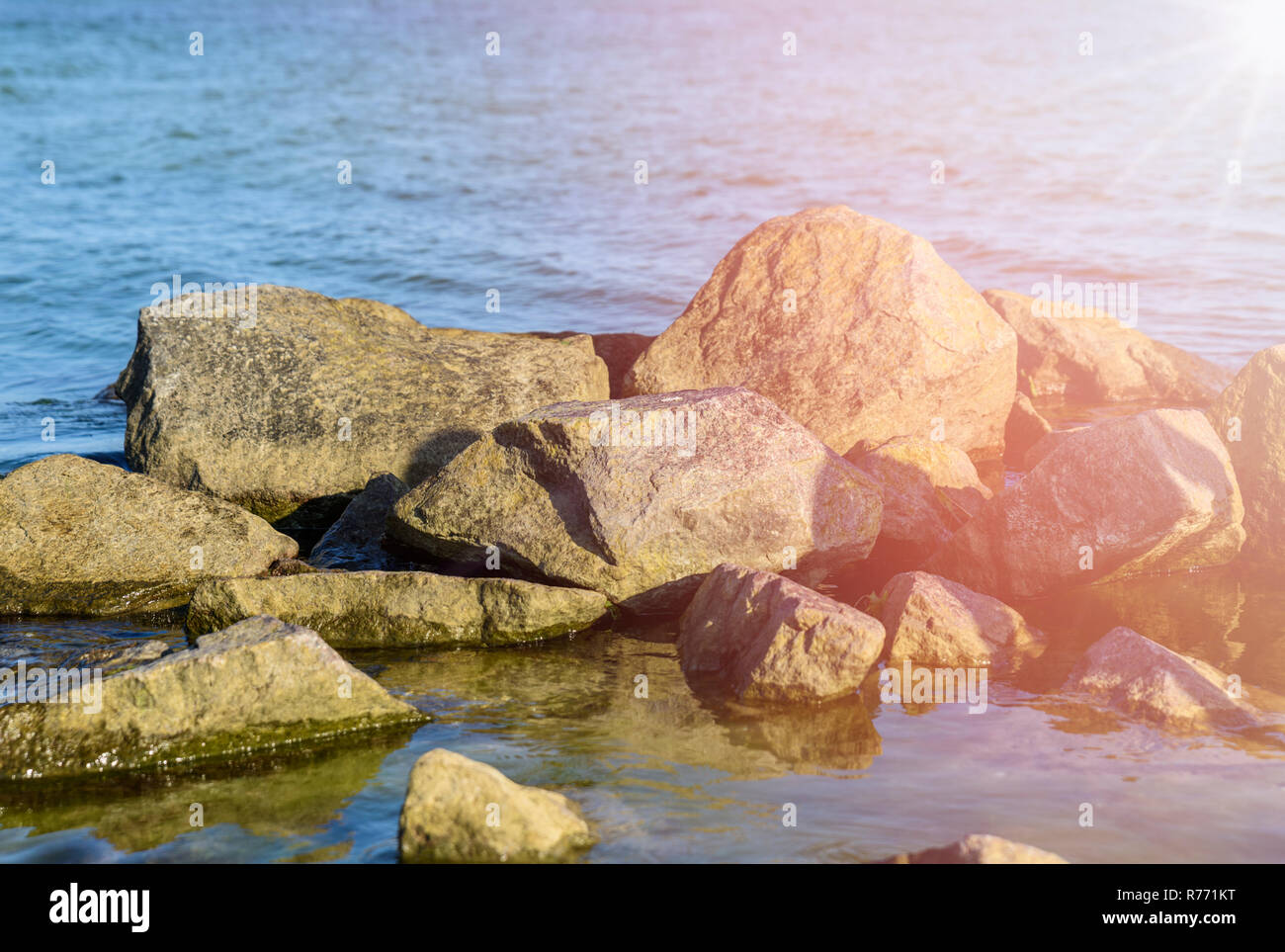 Large stones in sea water on a summer day Stock Photo - Alamy