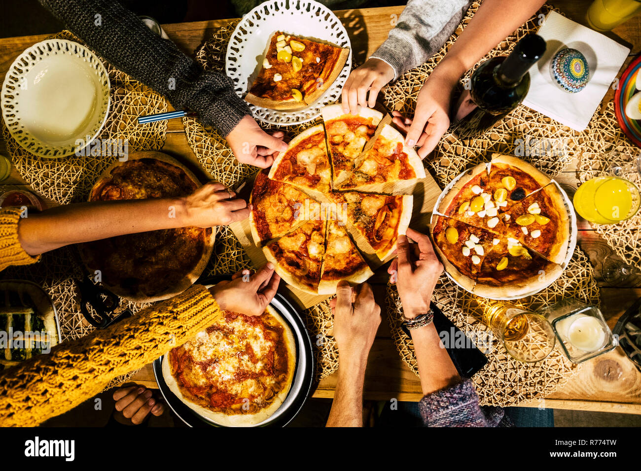 People eat pizza at festive table served for party. Friends celebrate ...