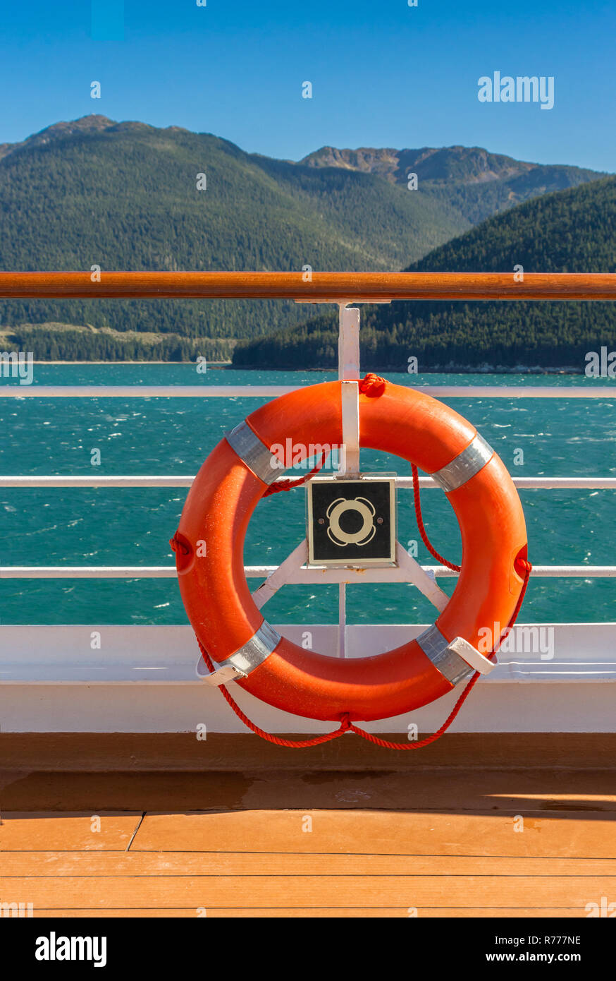 Bright orange plastic round life preserver in white metal holder ...