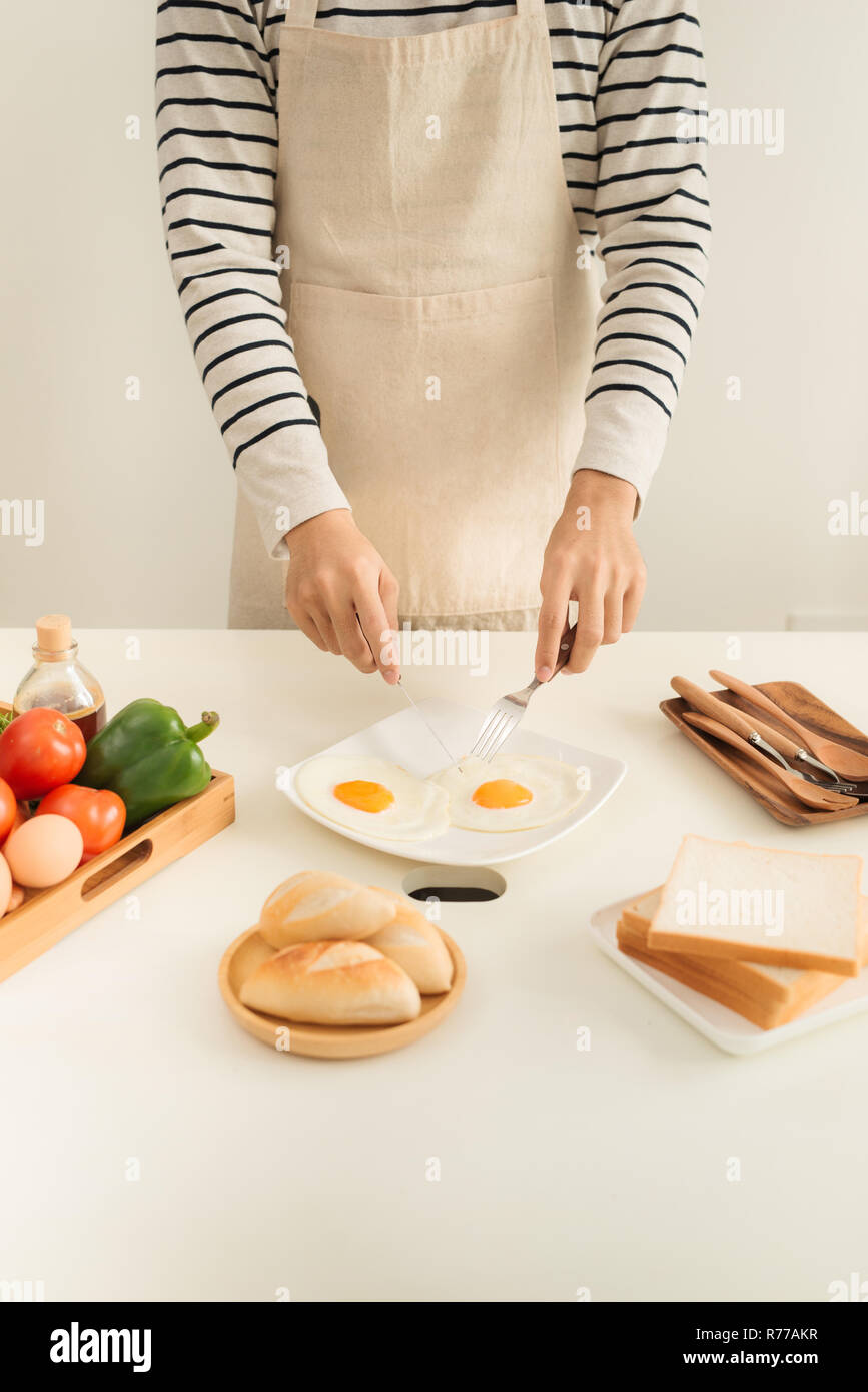 Hands of man prepare breakfast with eggs and bread Stock Photo - Alamy