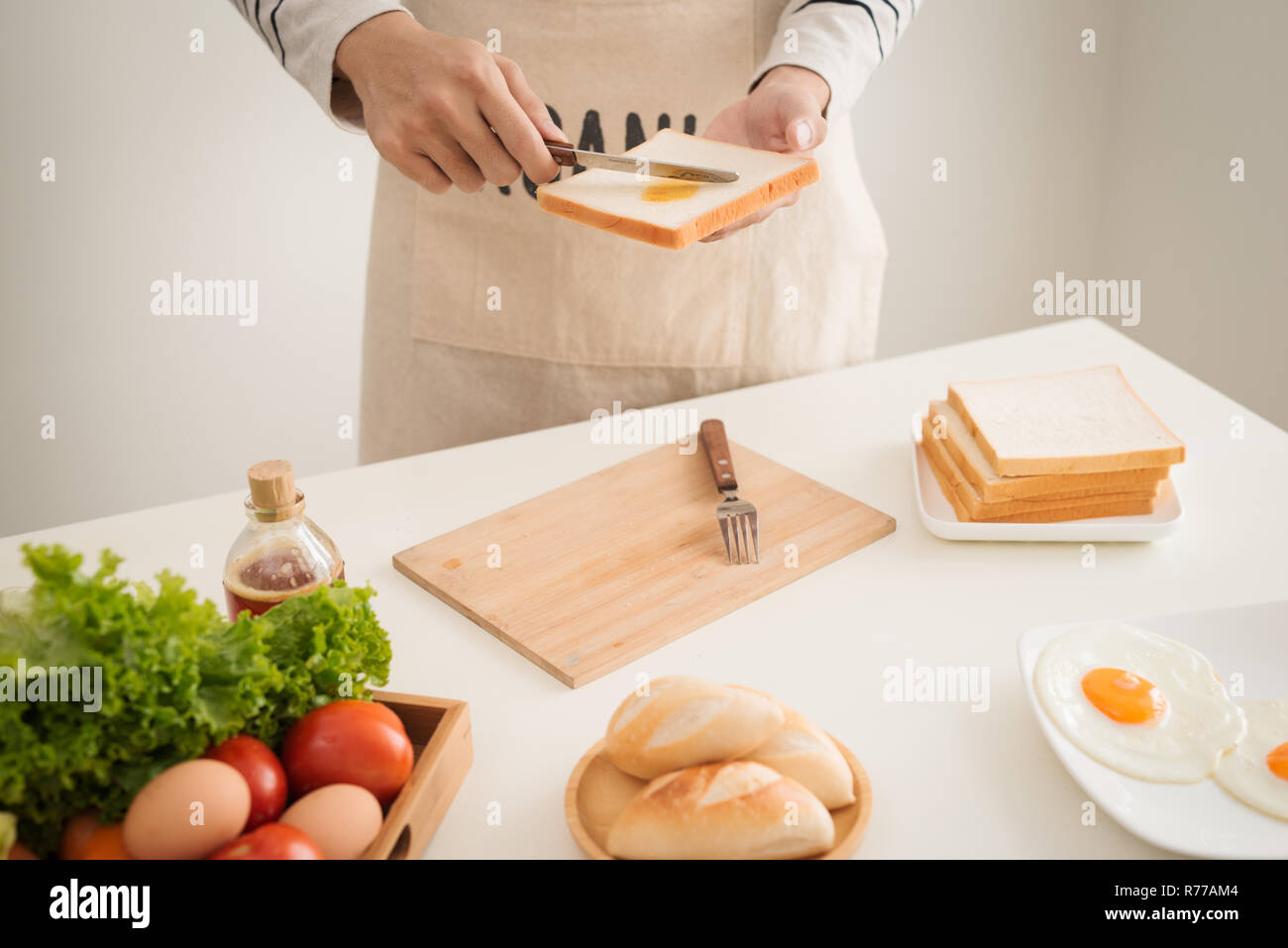 Hands of man prepare breakfast with butter and bread Stock Photo - Alamy