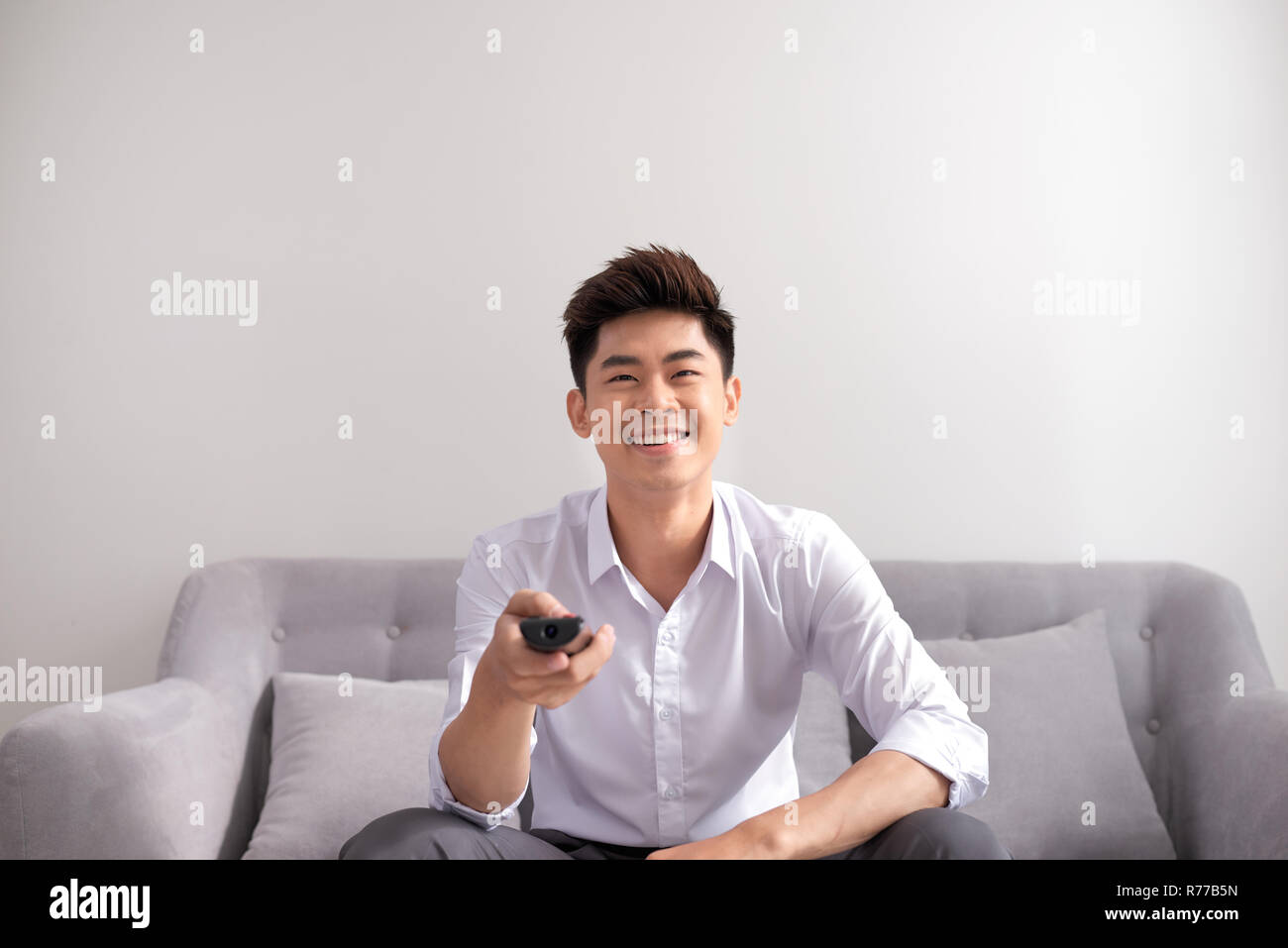 Shocking TV show. Handsome young man holding remote control and looking ...