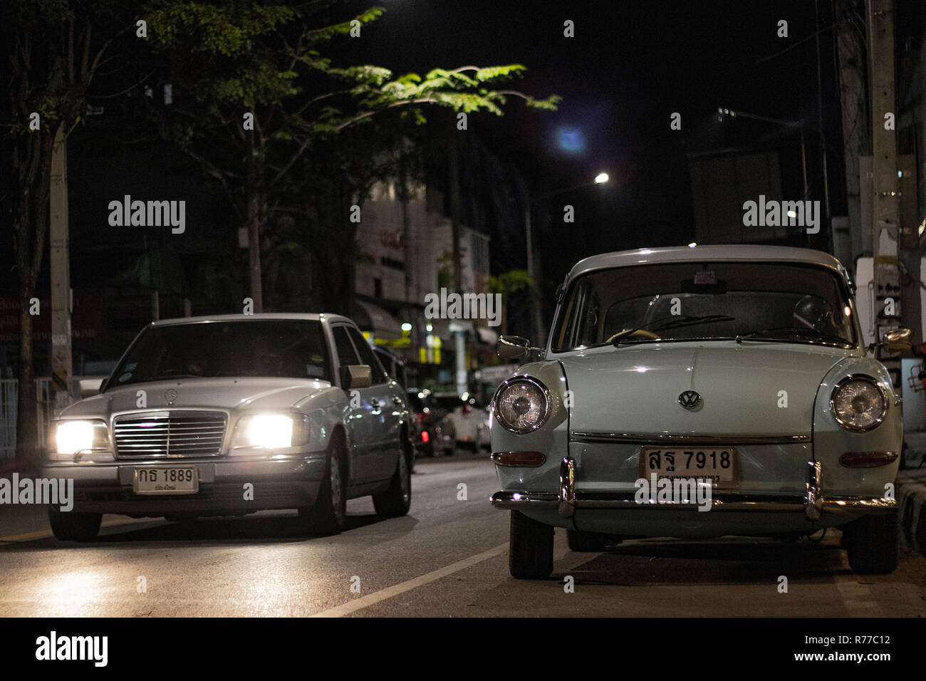Two vintage and classics cars in the street at night Stock Photo - Alamy