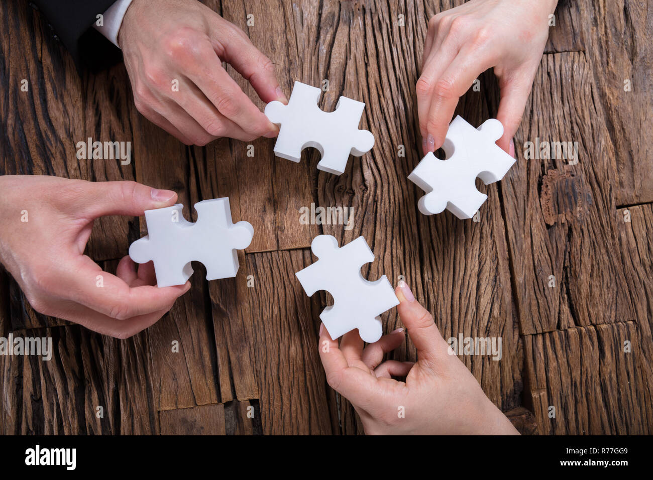 Group Of Businesspeople Solving Jigsaw Puzzle Stock Photo - Alamy