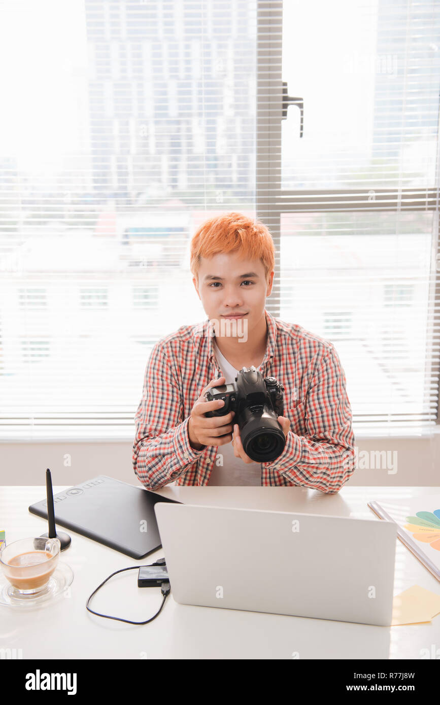 Photographer working at desk in modern office Stock Photo - Alamy