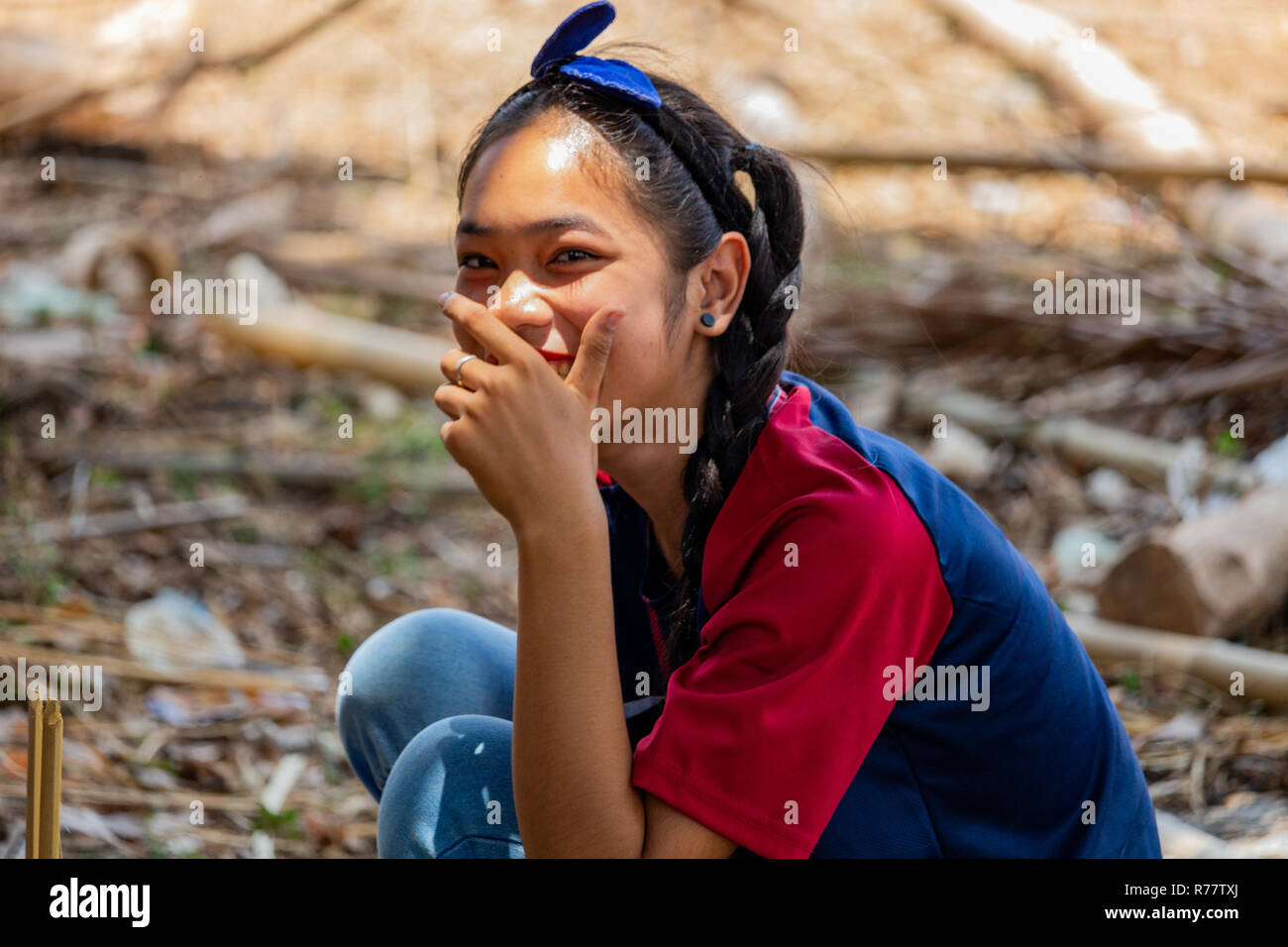 Don Daeng, Laos - April 27, 2018: Local girl cutting bamboo trees in a ...