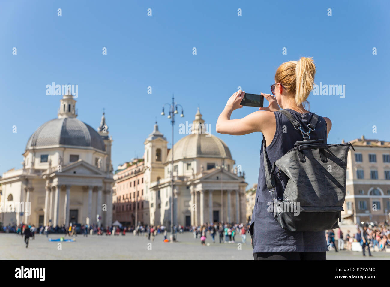 Female tourist with a fashinable vintage hipster backpack taking photo ...