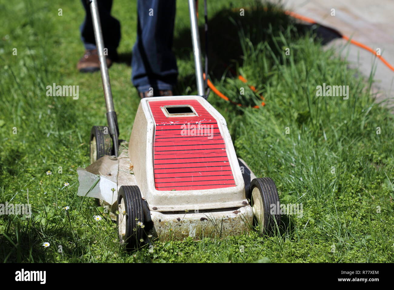 man mows lawn with electric mower Stock Photo - Alamy