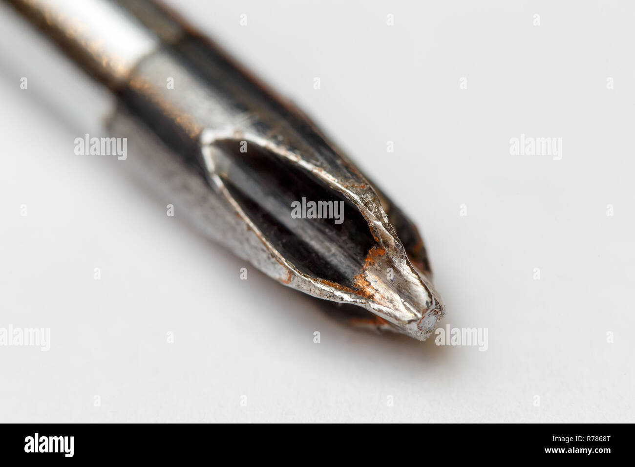 Cross tip of old screwdriver on white background. Extremely closeup ...