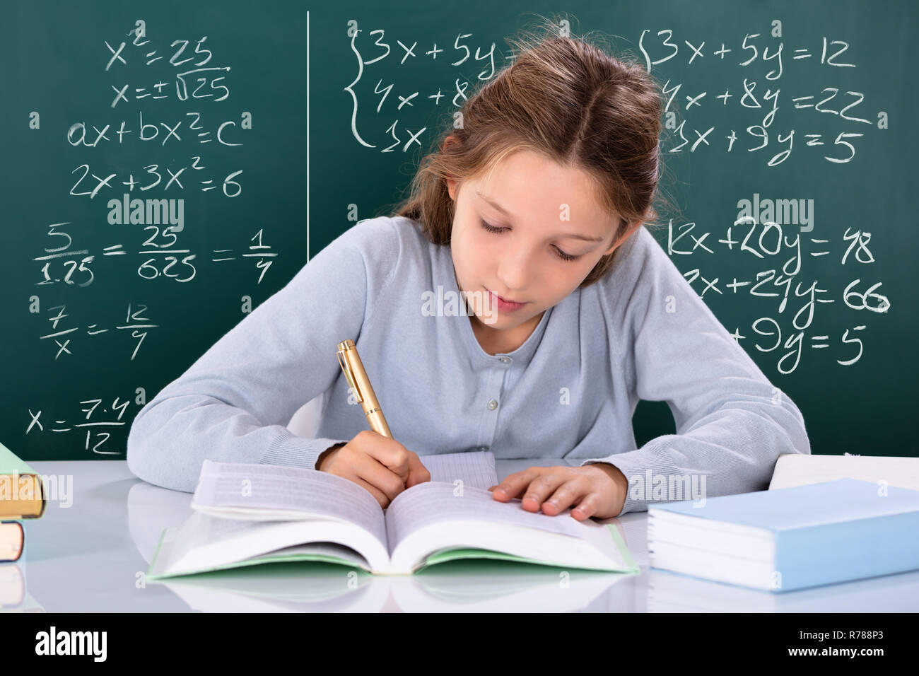 Portrait Of A Girl Doing Study In Front Of Green Chalkboard Stock Photo ...