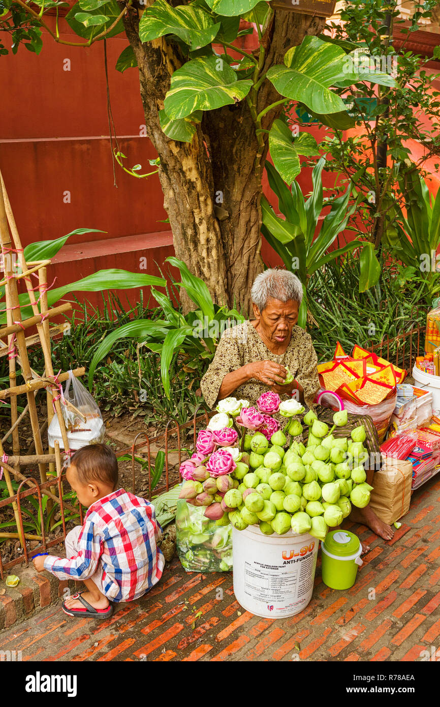 old woman selling lotus flowers and votive paper for Chinese New Year ...