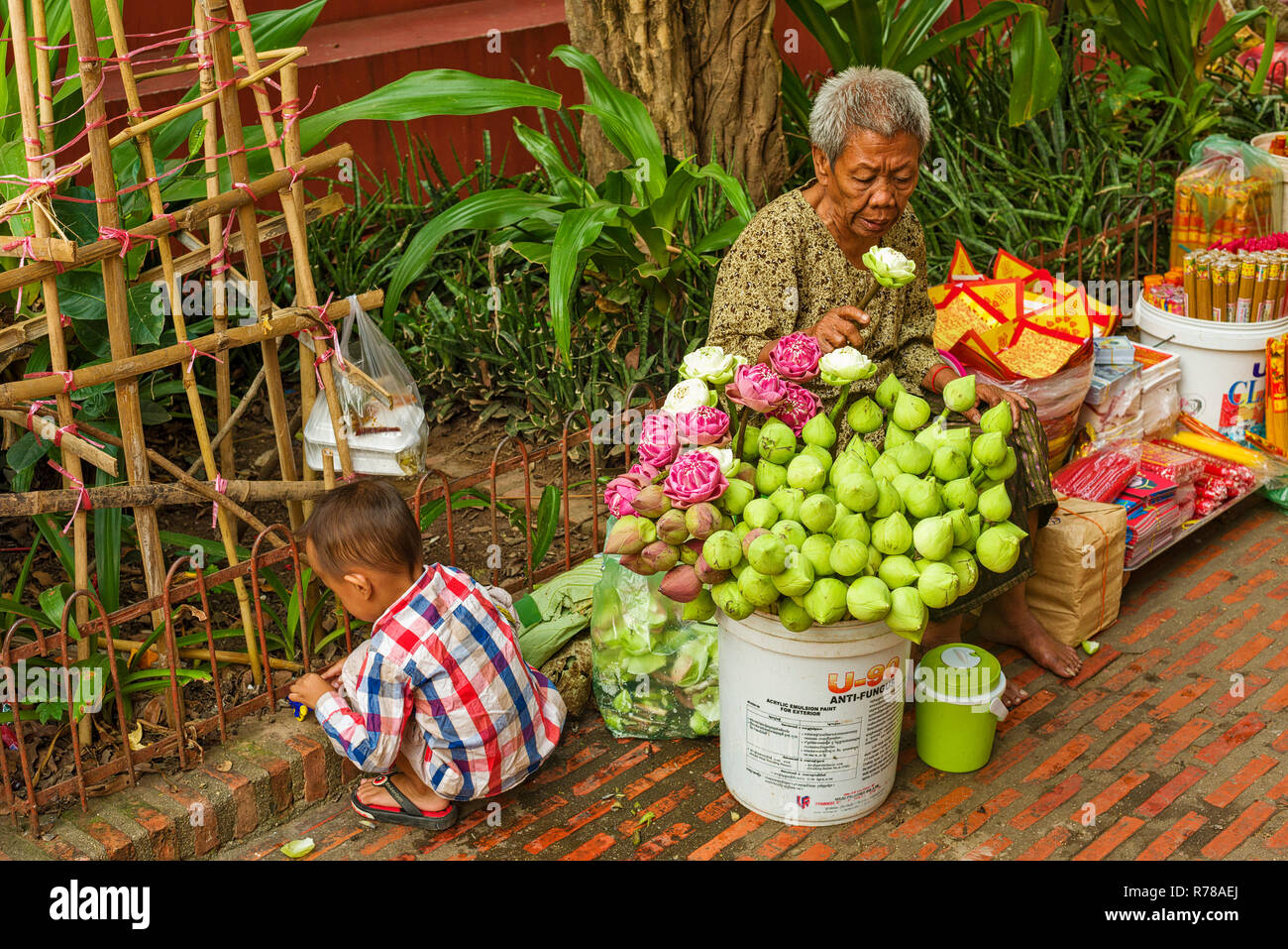 old woman selling lotus flowers and votive paper for Chinese New Year ...