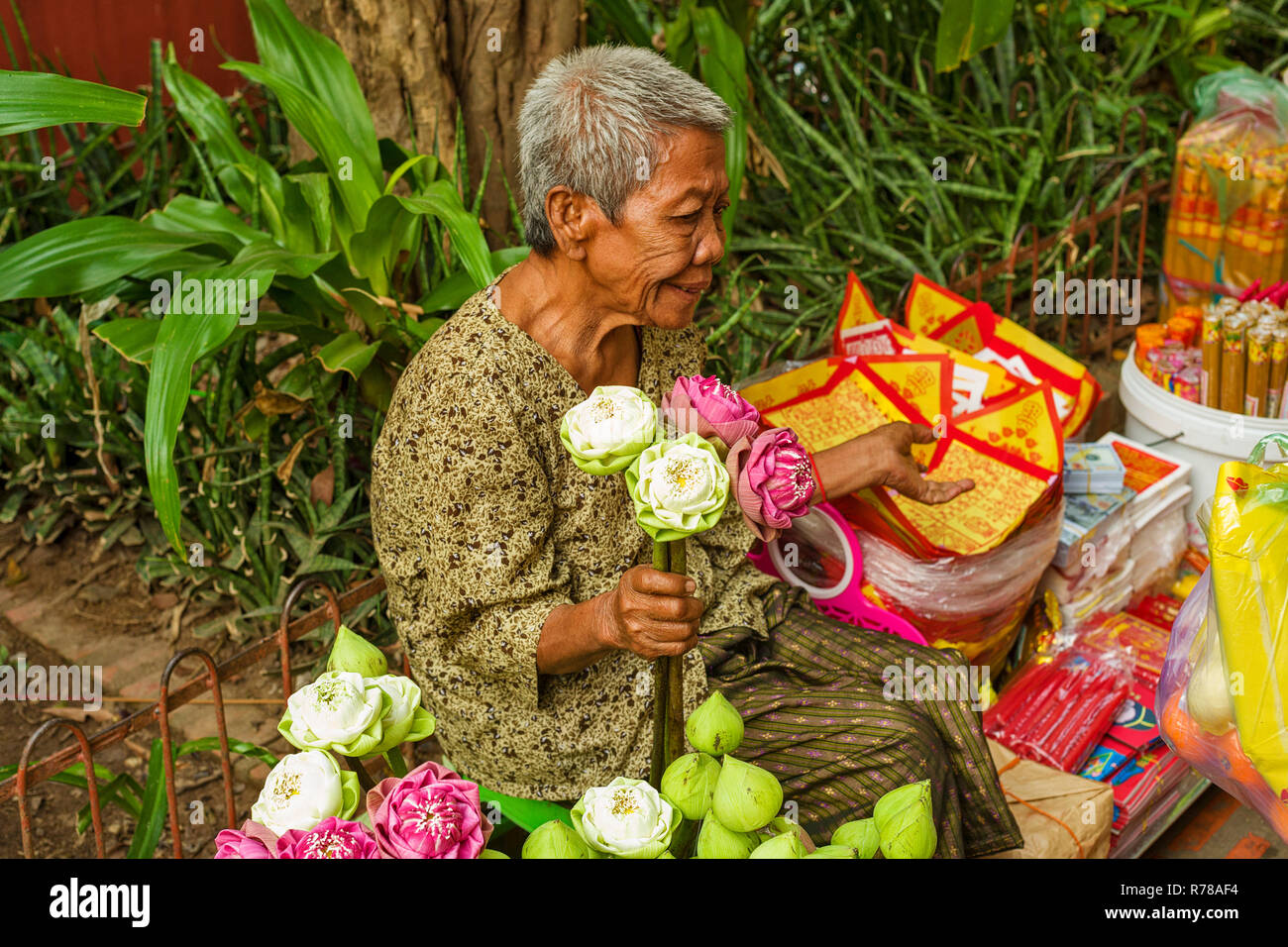 old woman selling lotus flowers and votive paper for Chinese New Year ...
