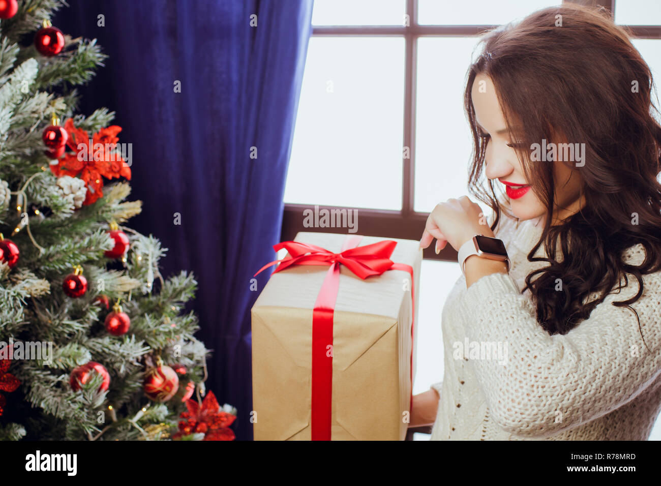 Happy young woman with gift box over christmas background Stock Photo ...