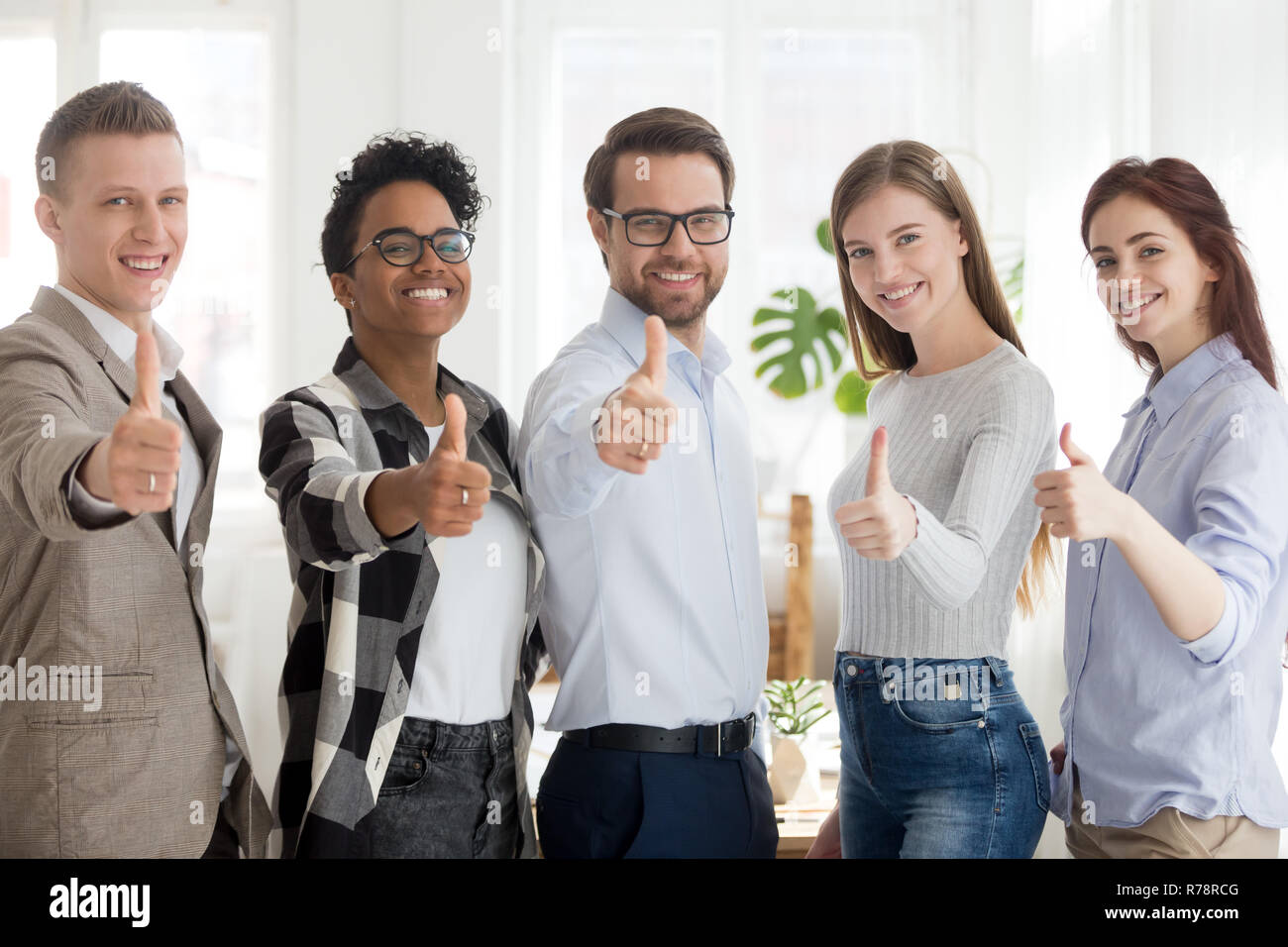 Happy millennial people standing showing thumbs up Stock Photo - Alamy