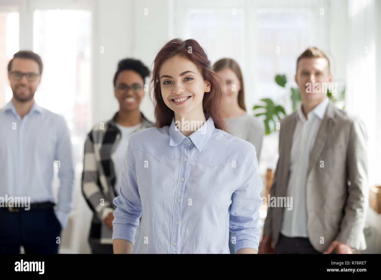 Portrait of smiling female employee foreground posing for pictur Stock ...