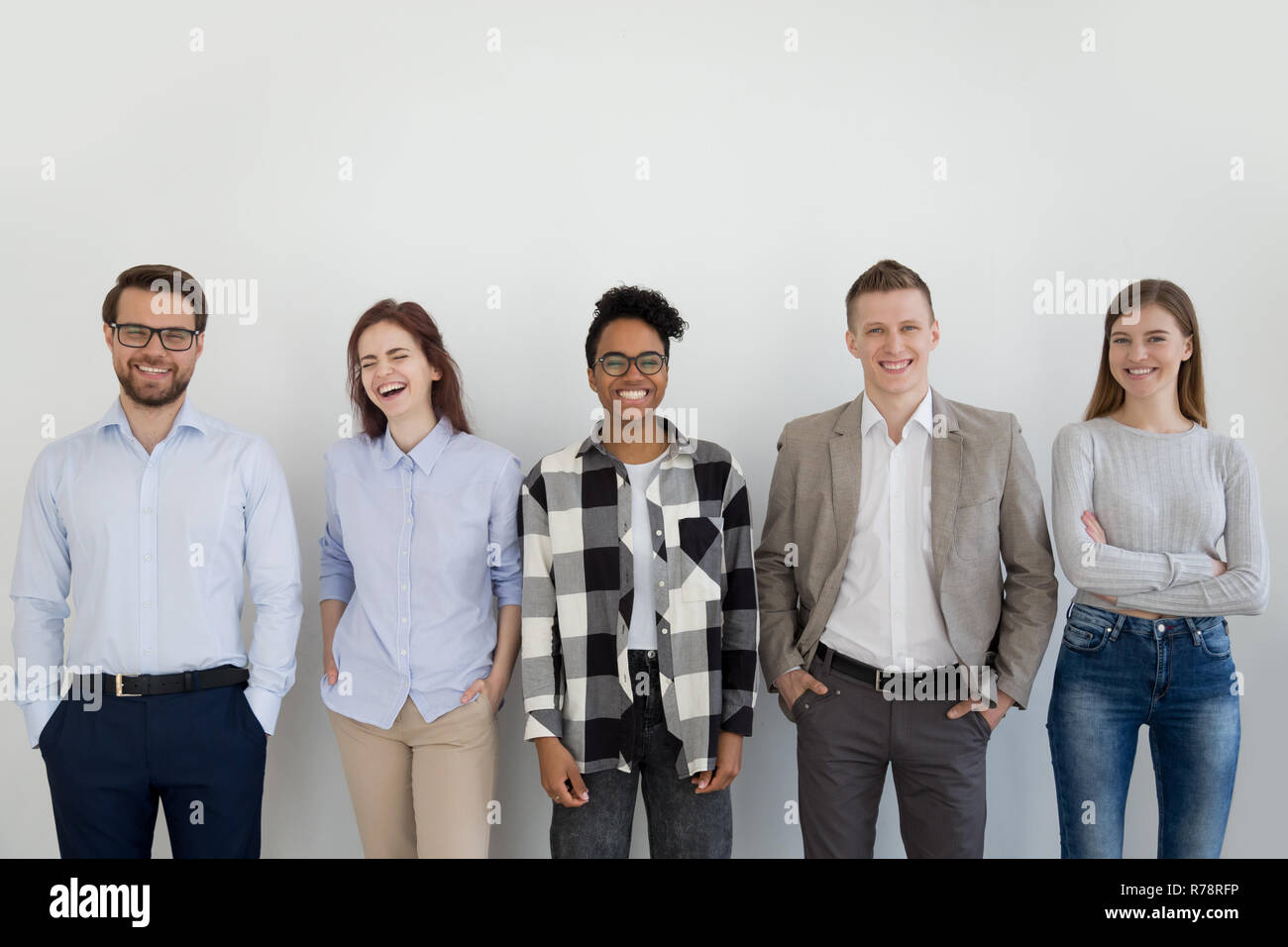 Diverse multiracial team of young people posing near wall Stock Photo ...