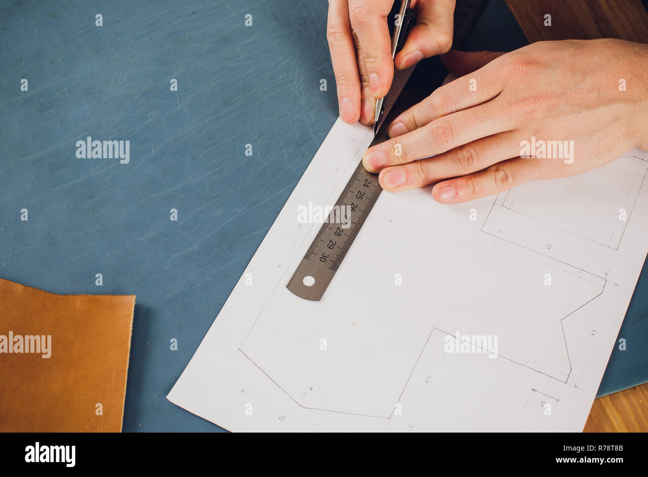 Working day in studio. Man leather worker drawing sketch of purse with ...