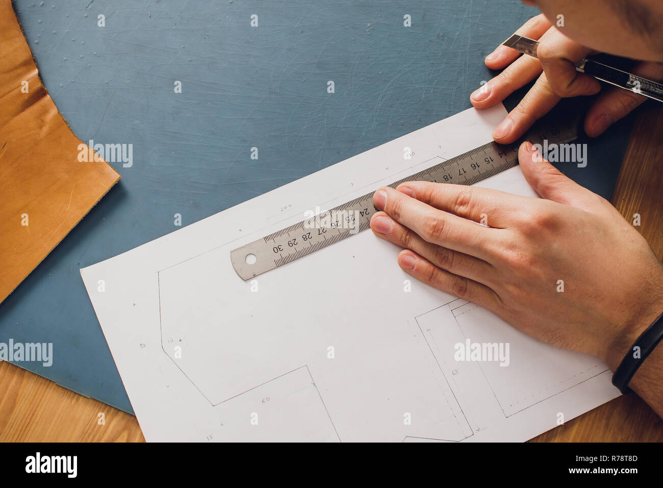 Working day in studio. Man leather worker drawing sketch of purse with ...