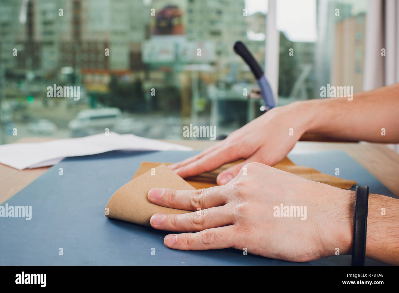 Working day in studio. Man leather worker drawing sketch of purse with ...