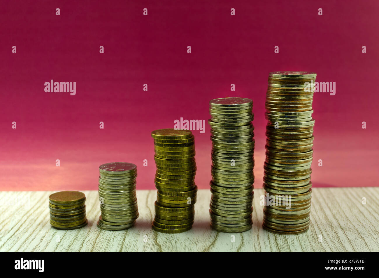 Five stacks of coins with growth between stacking limits on white ...