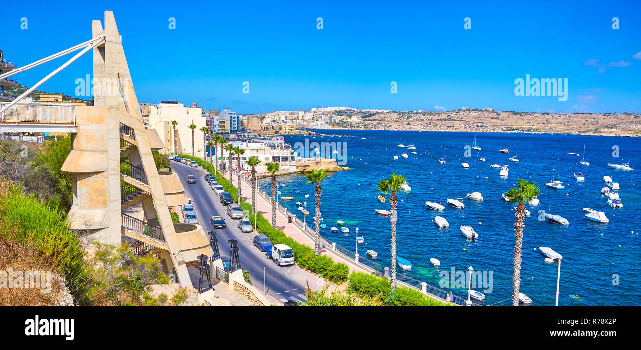 The seaside promenade of Bugibba resort with hilly coastline with ...
