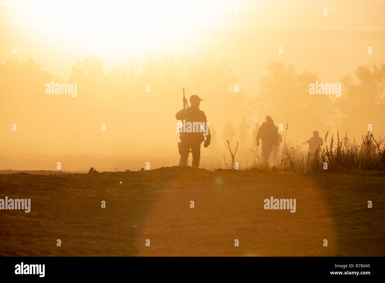 silhouette action soldiers walking hold weapons the background is smoke ...