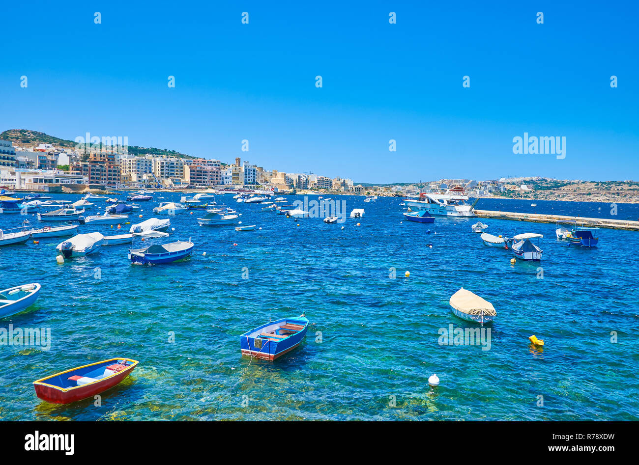 The fishing harbor with many small boats is surrounded by modern built ...