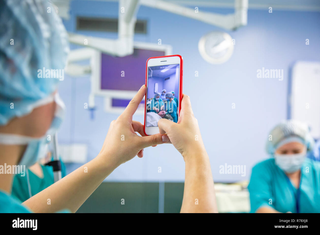 Assistant shooting on the smartphone from the operating room. Medical ...