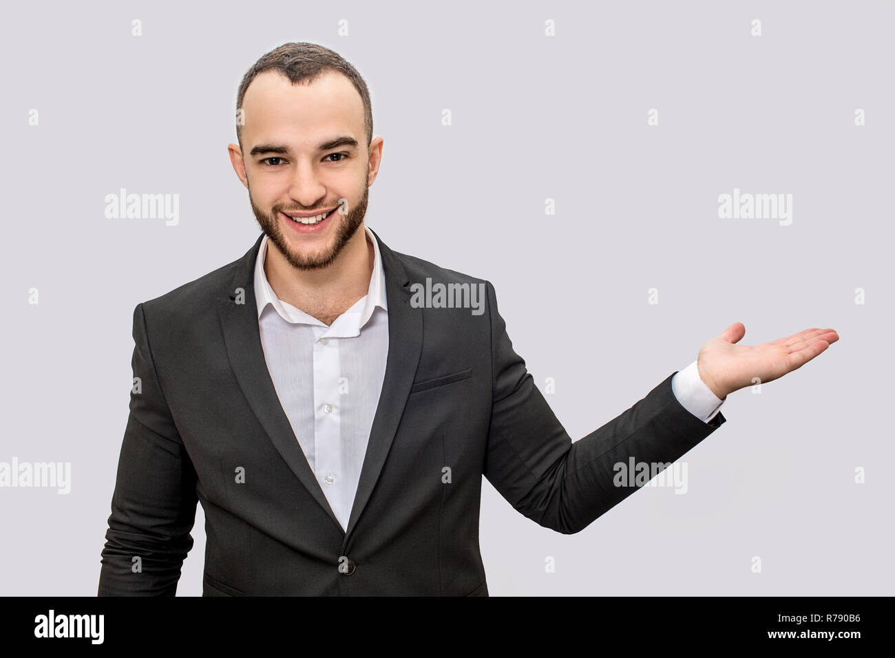 Cheerful and happy young man stand and hold hand aside of body. He ...