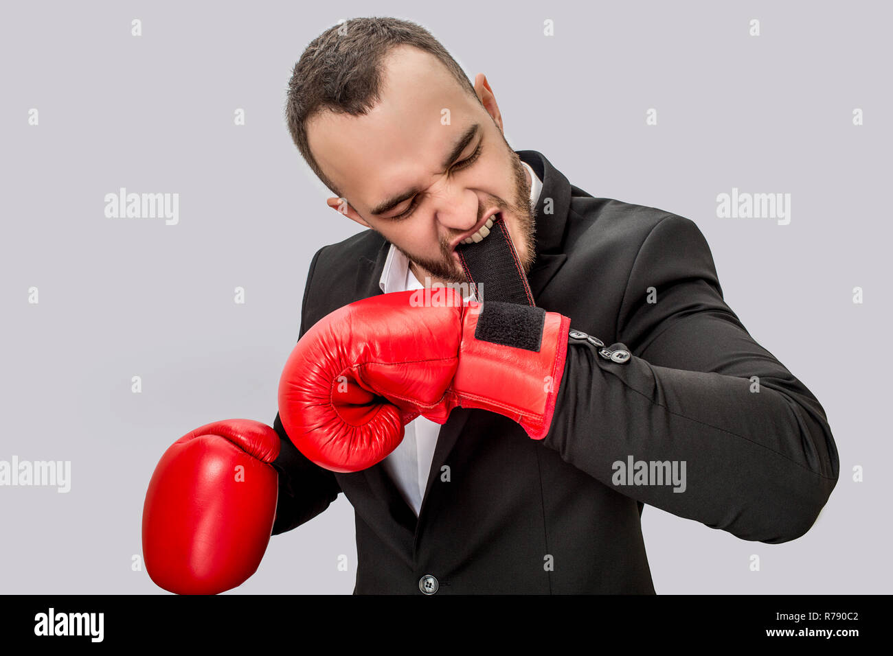 Serious and angry young man getting ready to fight. He holds clasp in ...