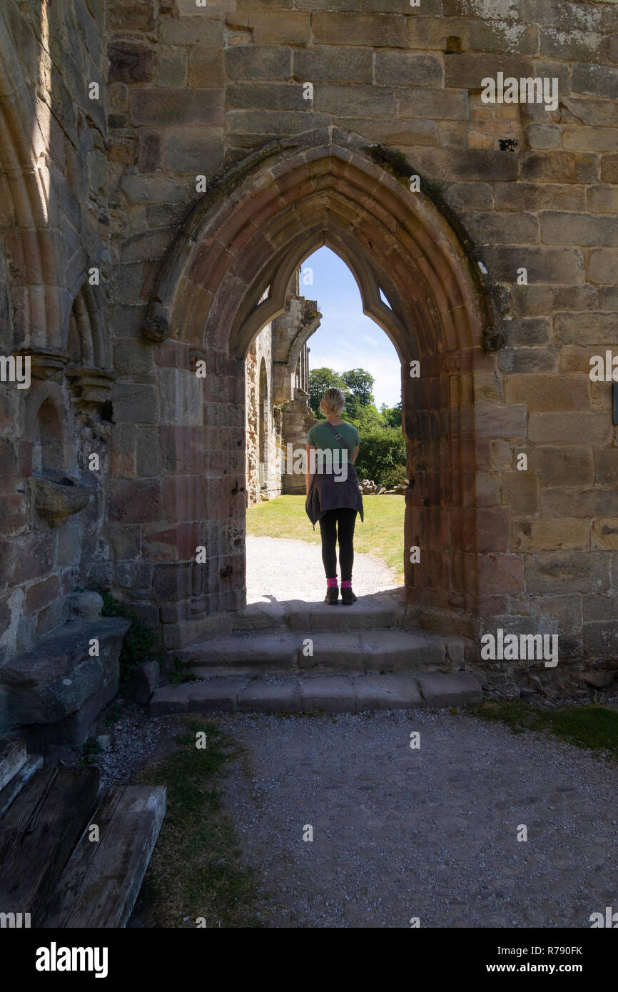 Woman stood in a medieval arched door way at Bolton Abbey, Skipton ...