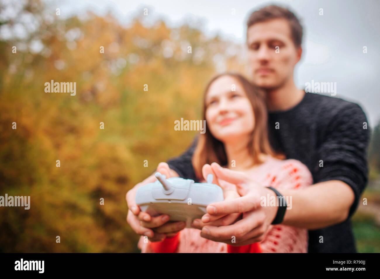 Picture of young man and woman standing together and holding remote ...