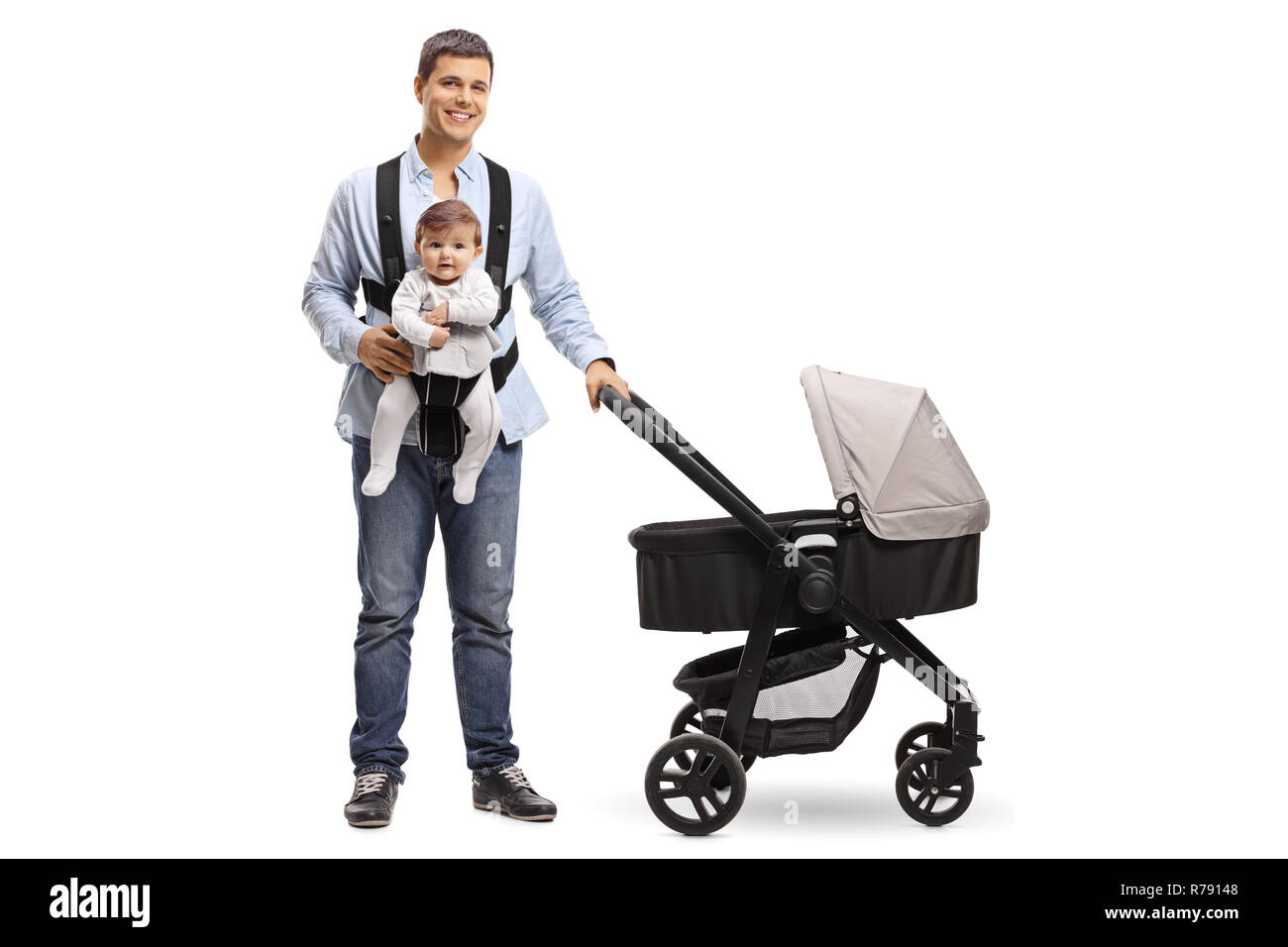 Full length portrait of a young father with a stroller and a baby in a ...