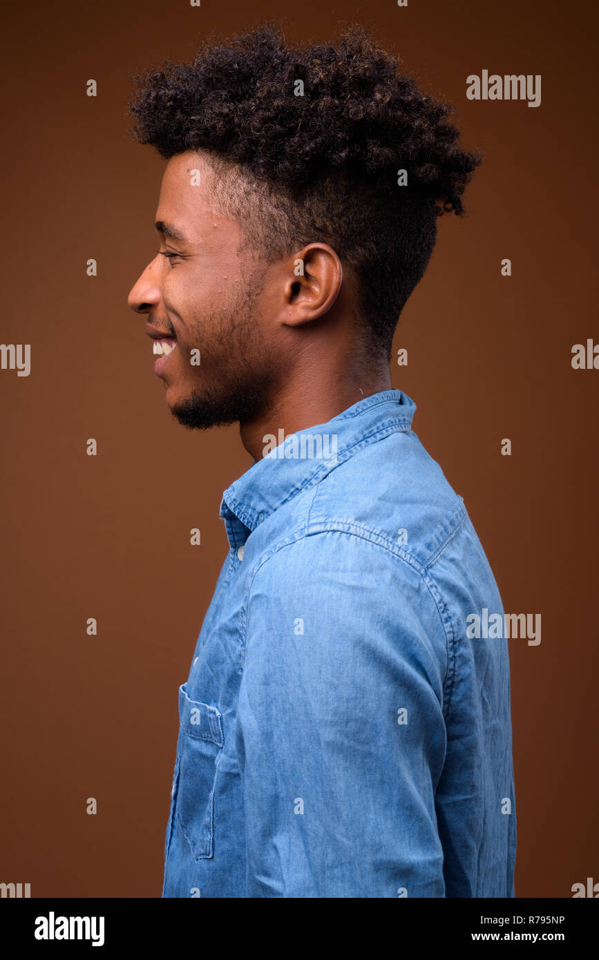 Profile view portrait of young handsome African man smiling Stock Photo ...