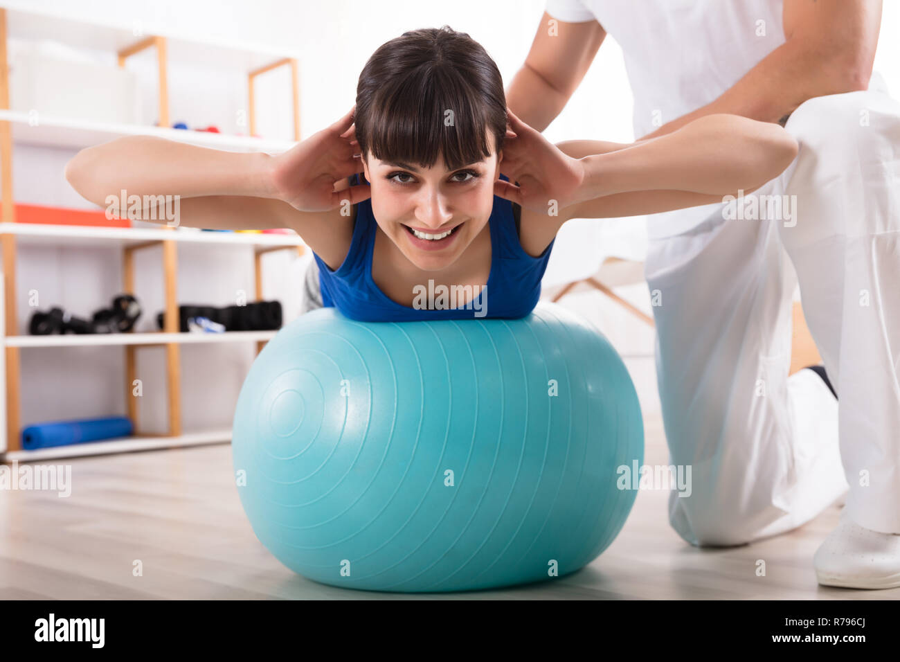 Physiotherapist Assisting Woman While Doing Exercise Stock Photo - Alamy