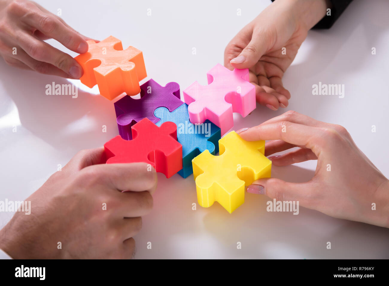 Group Of Businesspeople Solving Jigsaw Puzzle Stock Photo - Alamy