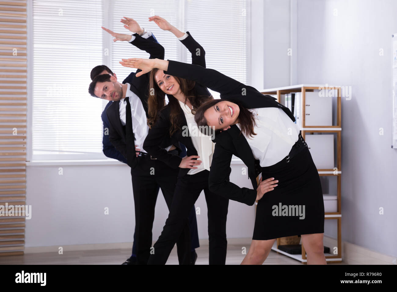 Businesspeople Doing Exercise In Office Stock Photo - Alamy