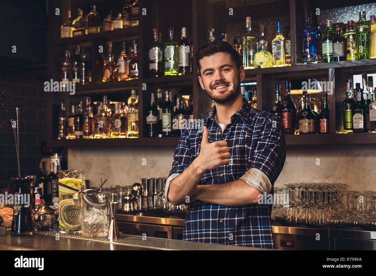 Young bartender standing at bar counter showing thumb up friendly Stock ...