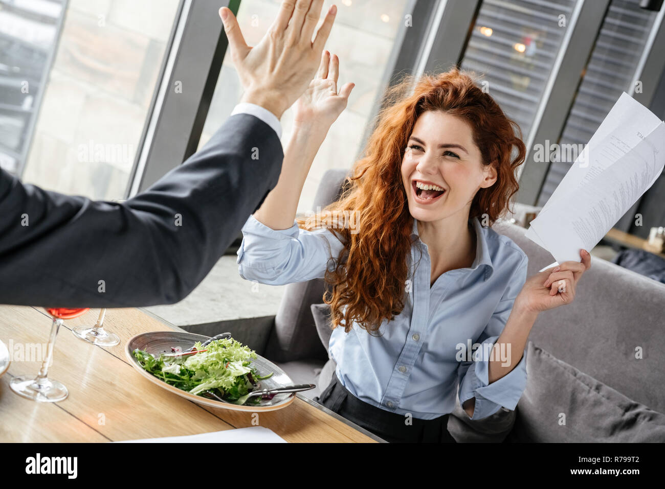 Businesspeople having business lunch at restaurant sitting eating salad ...