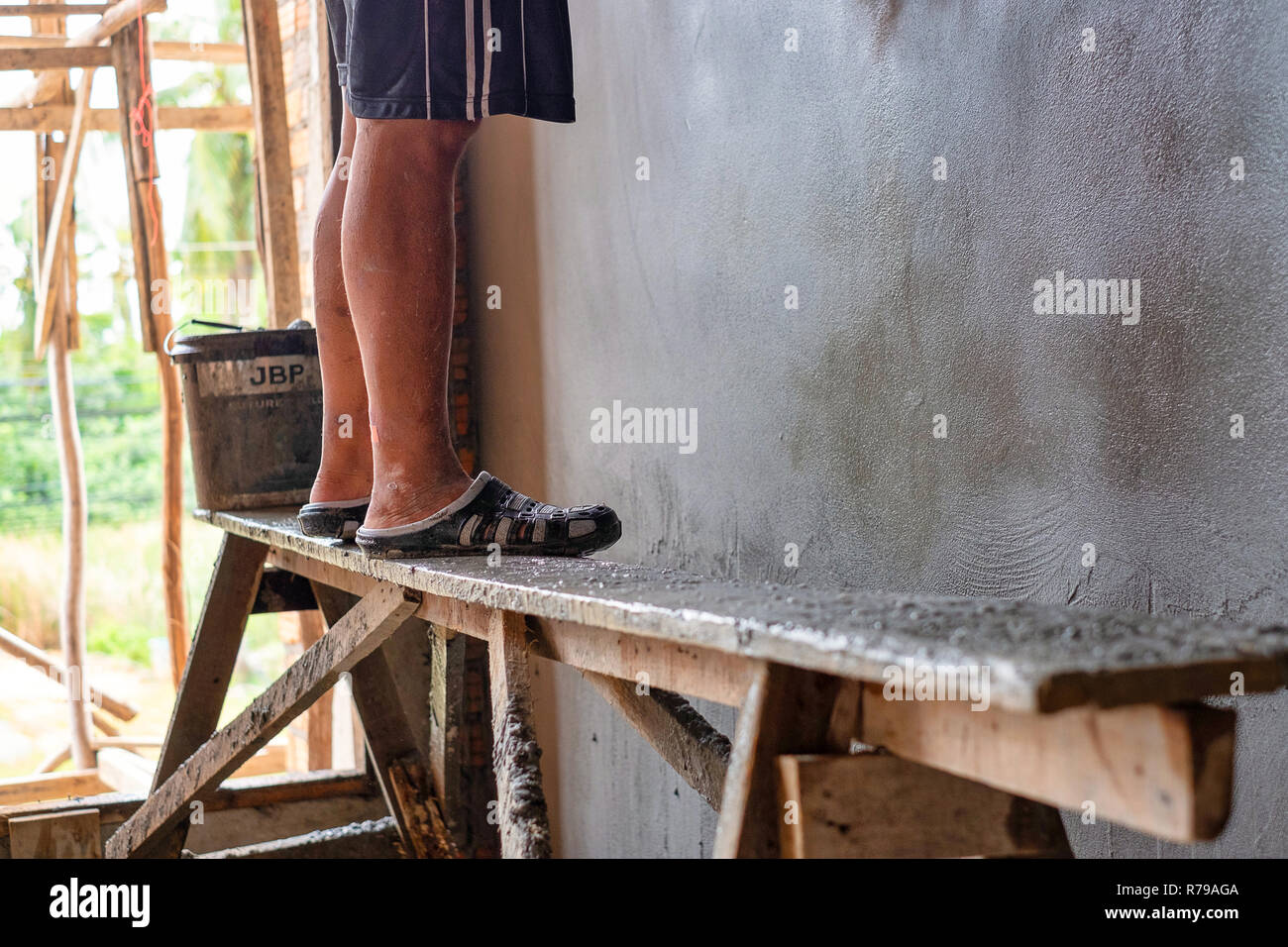 Showing legs of a man standing on the Wood bench while working in a ...
