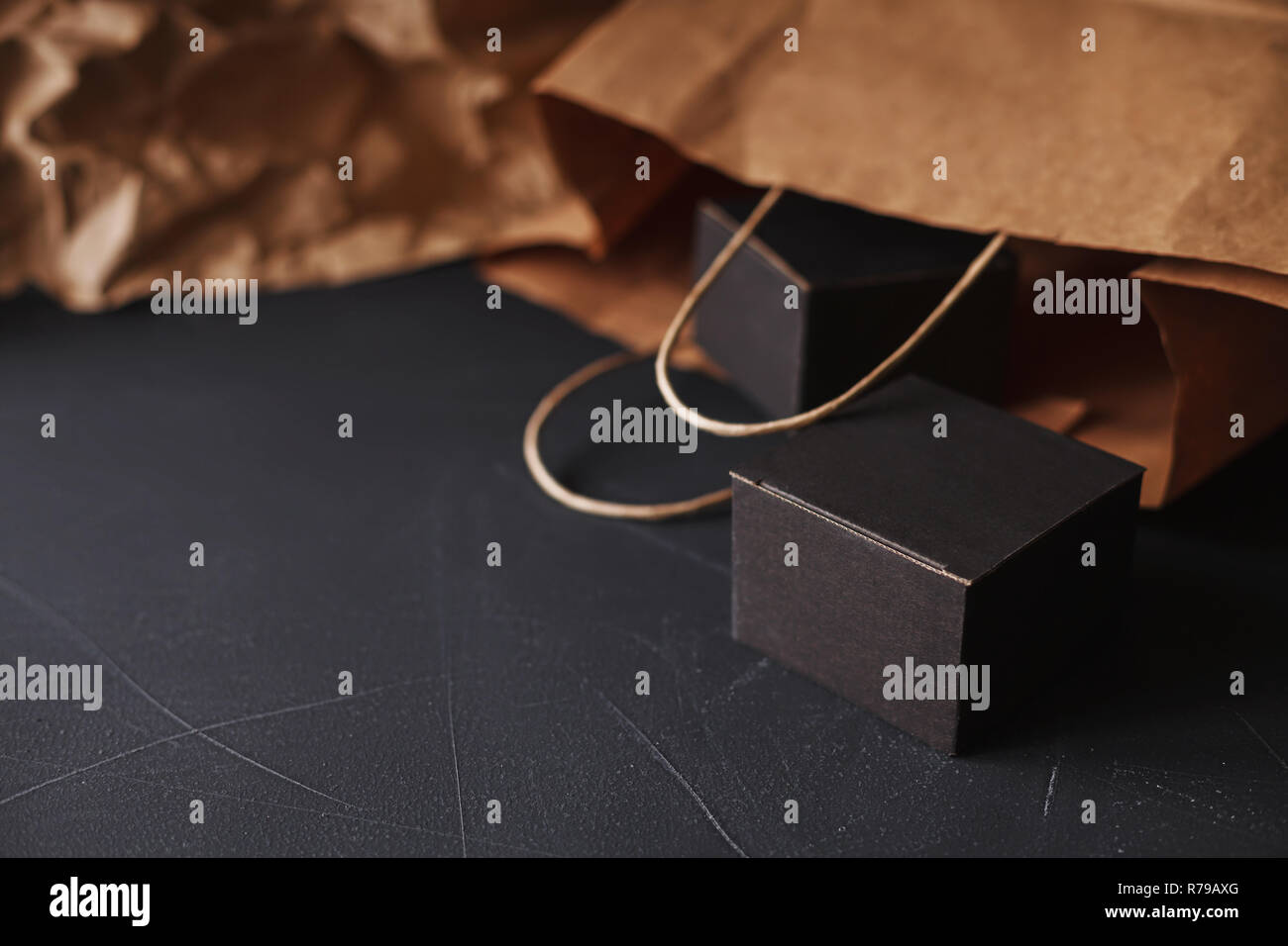 Two matte black carton gift boxes laying on a black painted scratched ...