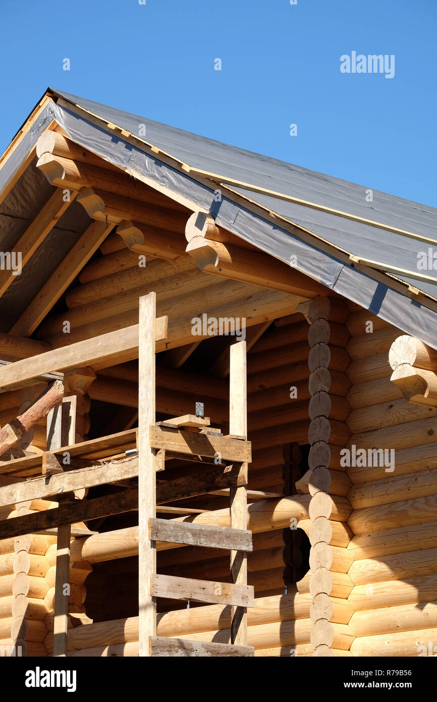 Process of wooden rural house straight roof slope mounting on cloudless ...