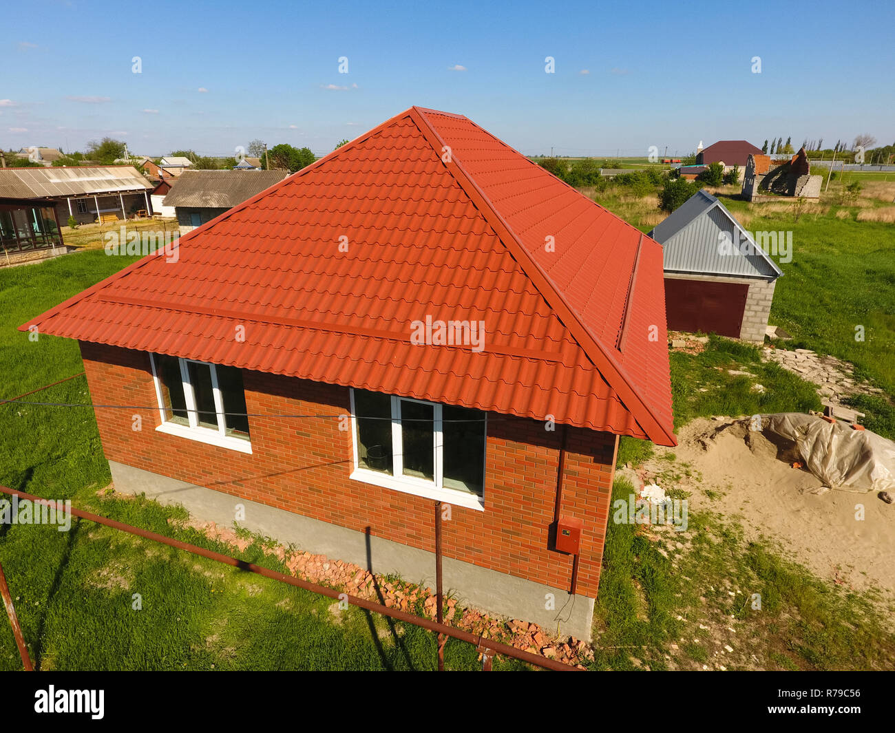 House with an orange roof made of metal, top view. Metallic profile ...