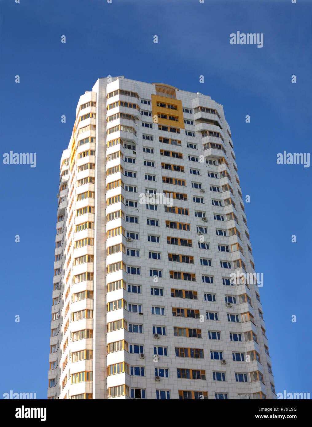 Front view of high new constructed residential building over clear blue ...