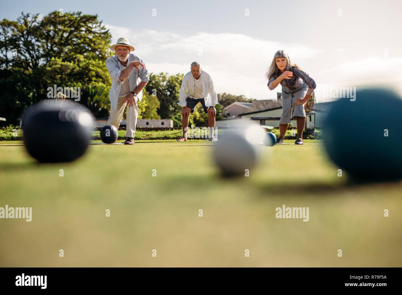 Senior man and woman playing boules competing with each other. Ground ...