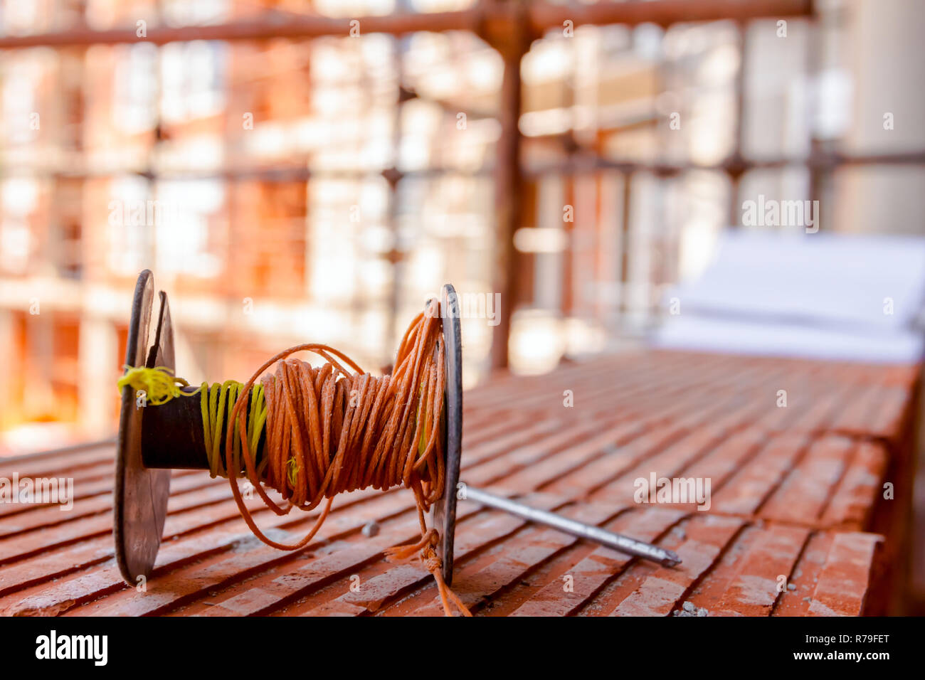 Spool of construction string line is placed on red blocks. Tool to help ...