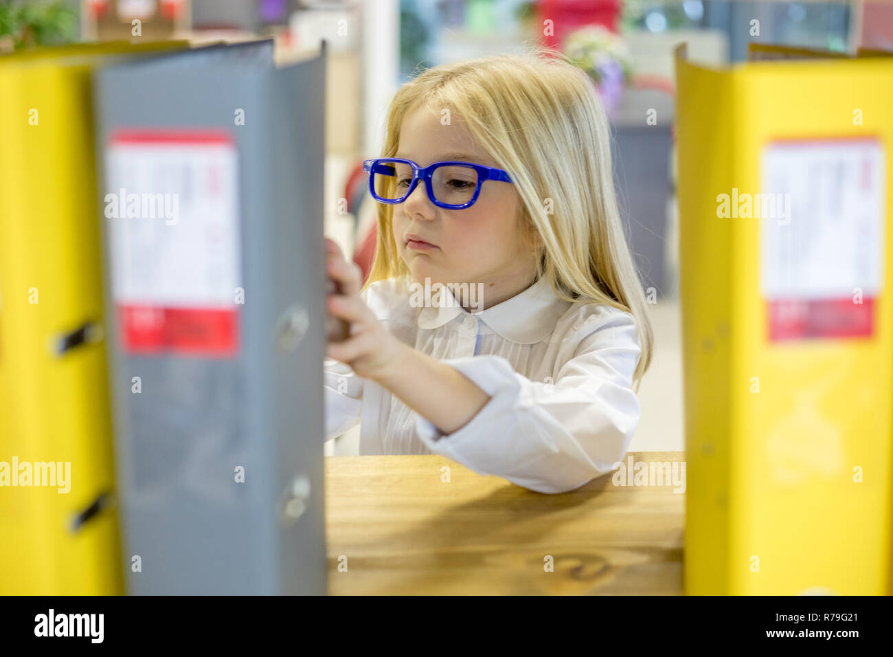 Little girl among the folders with documents. Business children Stock ...