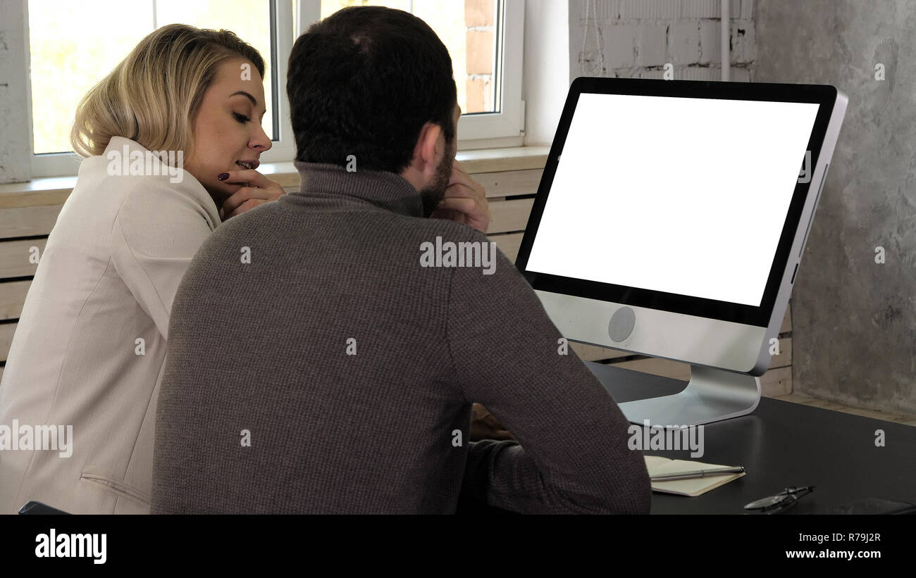 Businesspeople co-working comparing a desktop computer information at ...