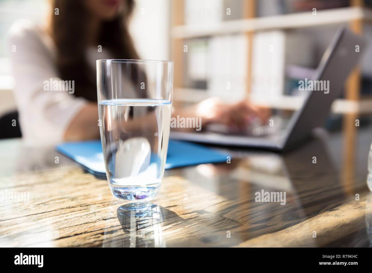Glass Of Water On Desk Stock Photo - Alamy